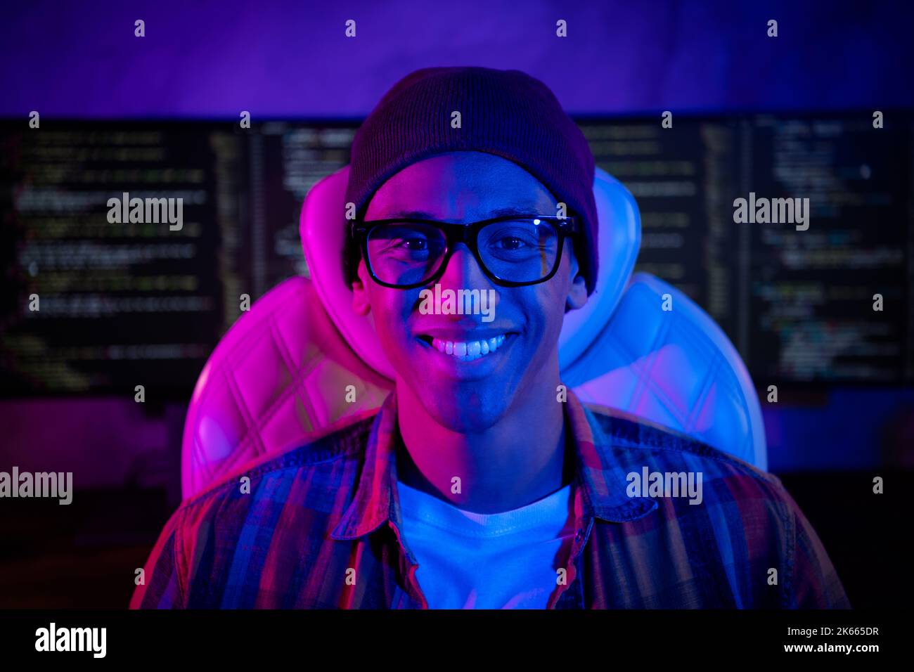 Portrait of cheerful intelligent hacker guy sitting chair toothy smile ...