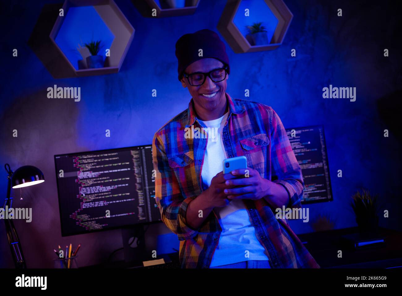 Photo of smart hacker guy hold use telephone server security operating evening workstation room ...