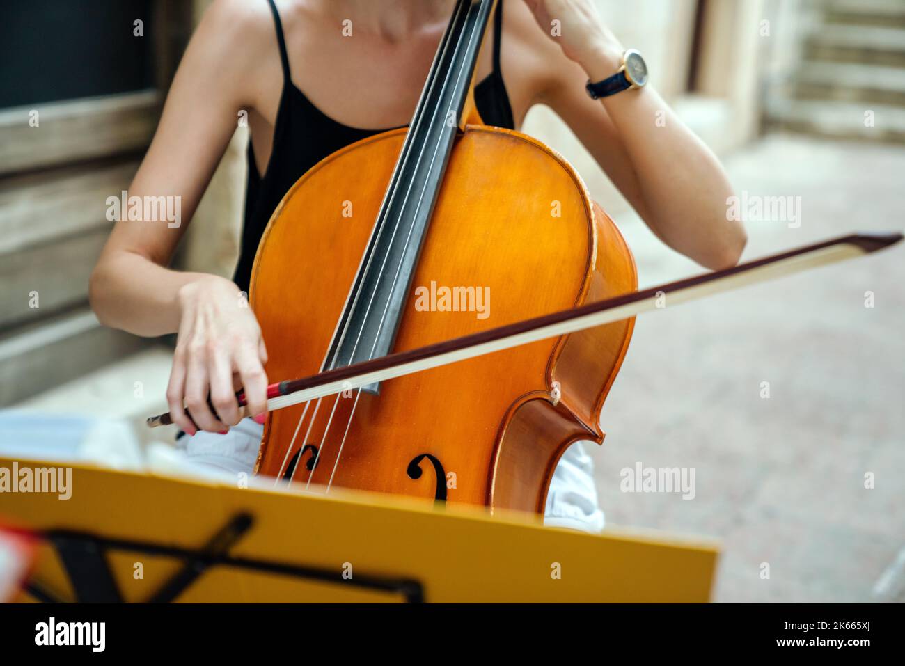 Happy young female musician playing the cello Stock Photo - Alamy
