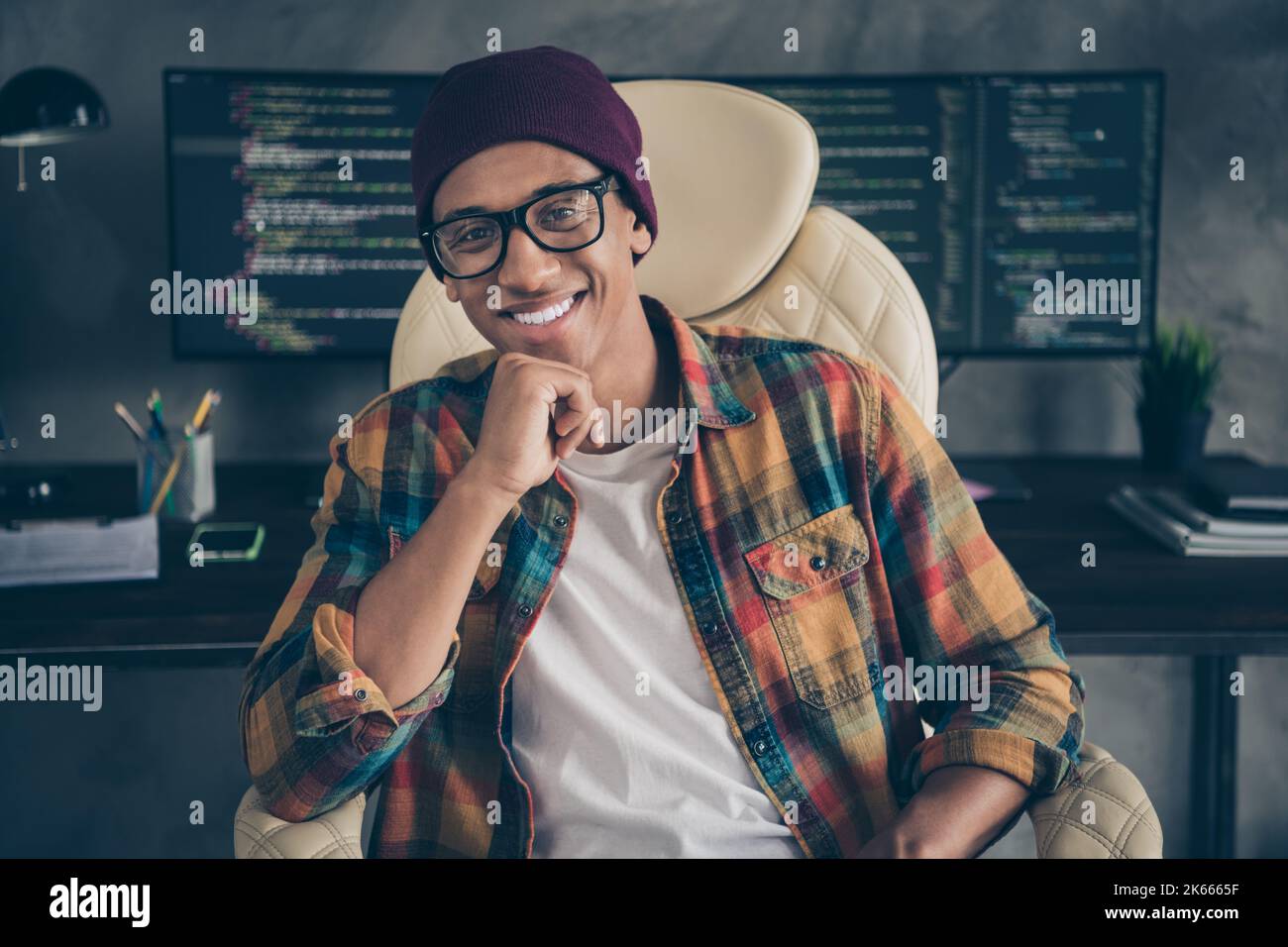 Photo of cheerful person hardware expert sitting chair hand touch chin ...