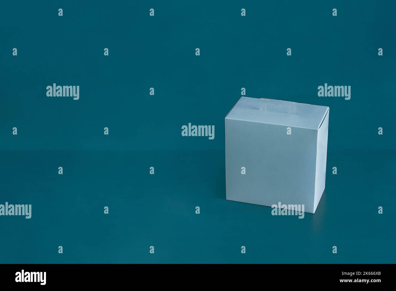 A blank blue square cardboard box on a colorful blue studio background ...