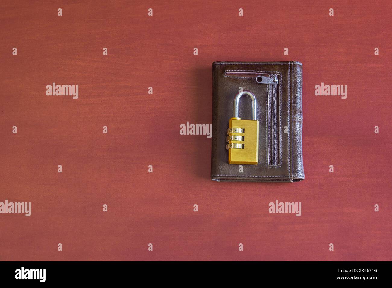 An isolated old leather wallet with a numeric closed gold padlock on ...