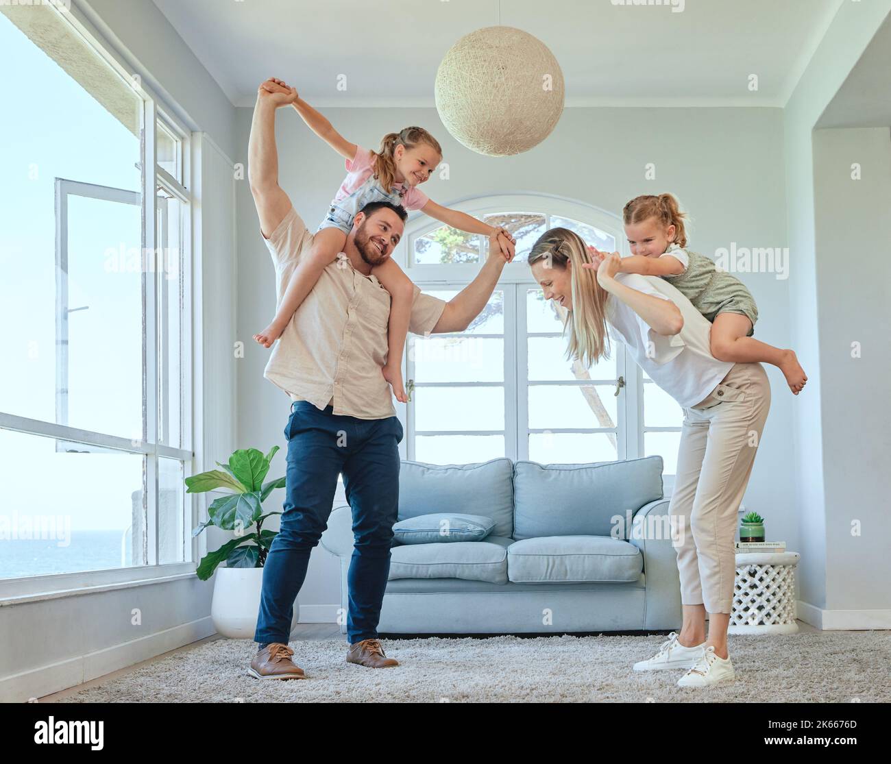 Daily playtime. a young family having fun together in the lounge at ...