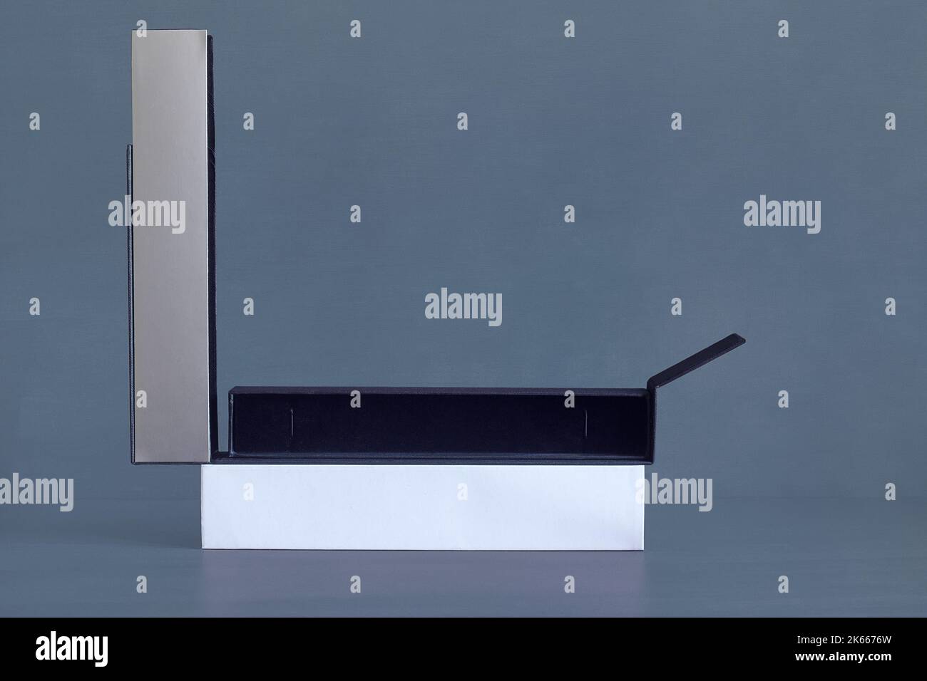 A long, thin rectangular box with the silver-grey lid open, revealing ...