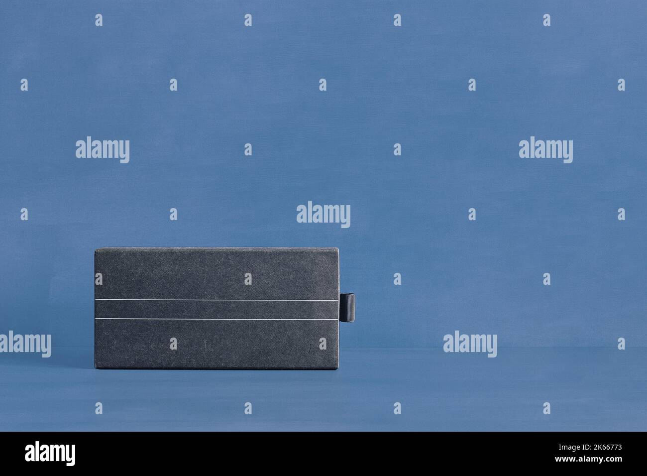 A stylish textured rectangular cardboard box with two thin white lines ...