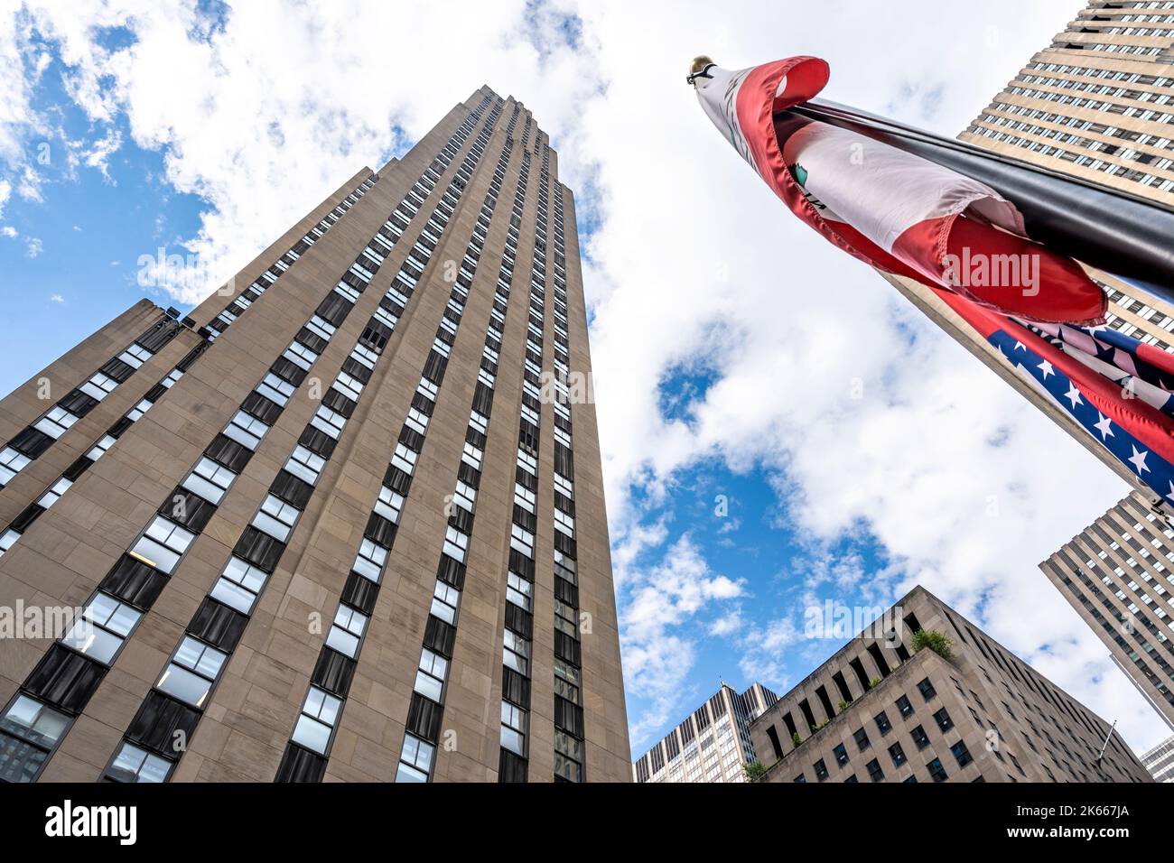 Skyscraper in Rockefeller Plaza with American flag, vertical ...