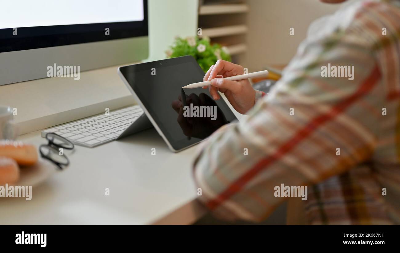 A female college student or designer in a flannel shirt working at her ...