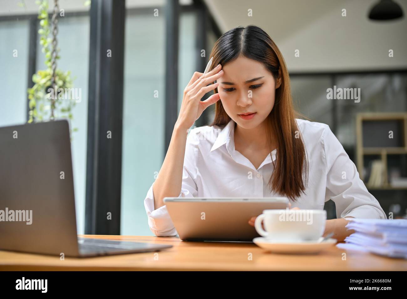 Stressed and serious young Asian businesswoman or female marketing ...