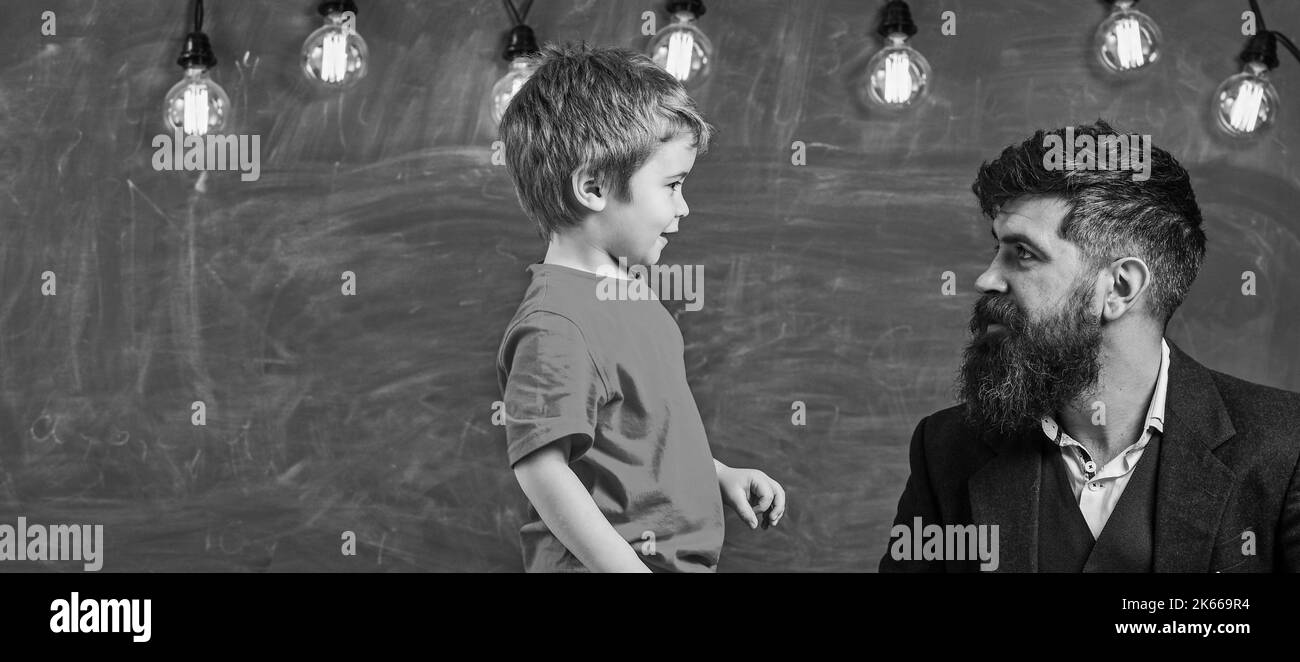 Daddy and kid staring at each other. Adult male and small boy side view ...