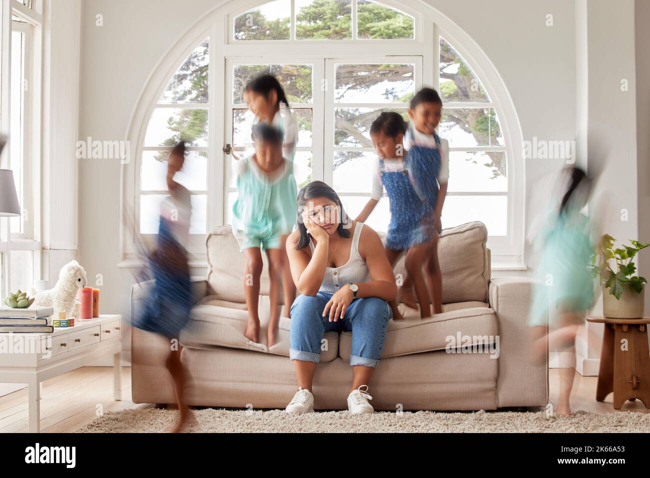 Young single mother looking stressed by her energetic children running ...