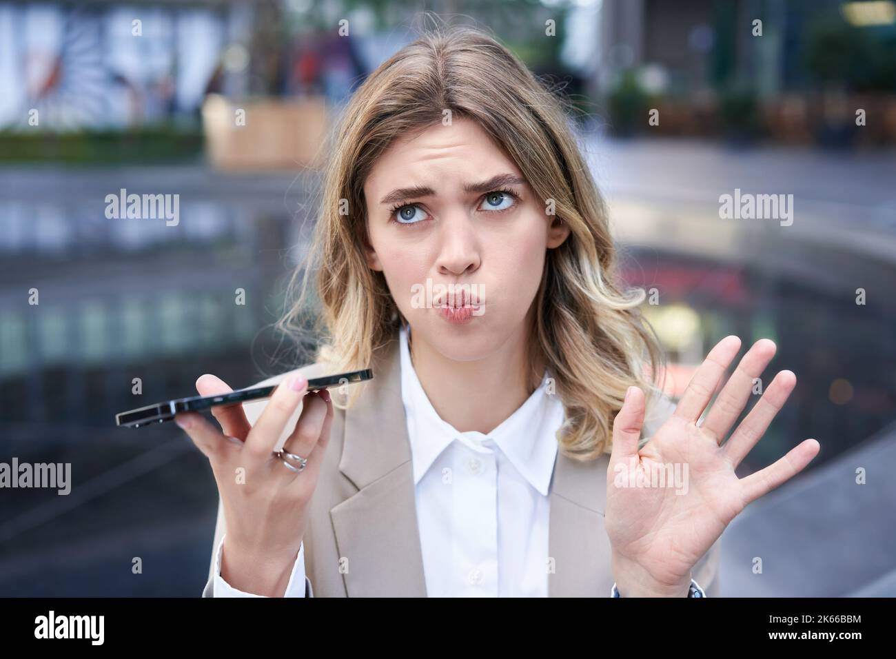 Portrait of confused businesswoman recording voice message, counting ...