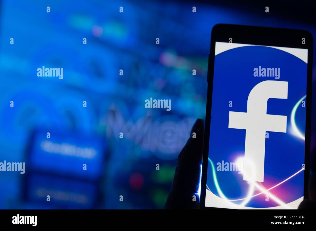 A smartphone with Facebook logo on the screen against the blurry ...