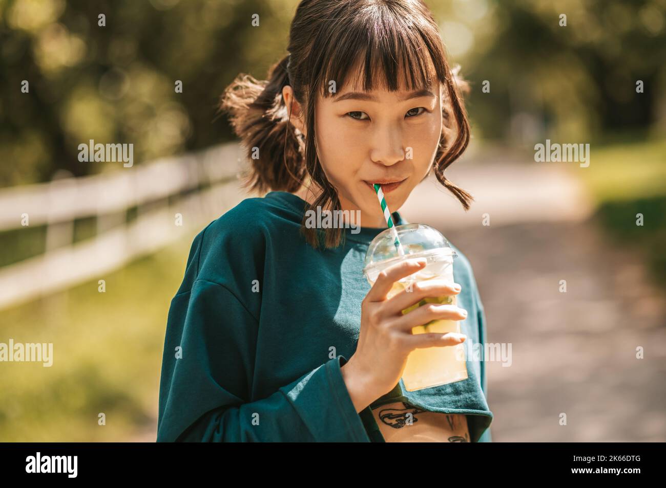 Cute asian girl drinking lemonade thriguh the straw Stock Photo - Alamy