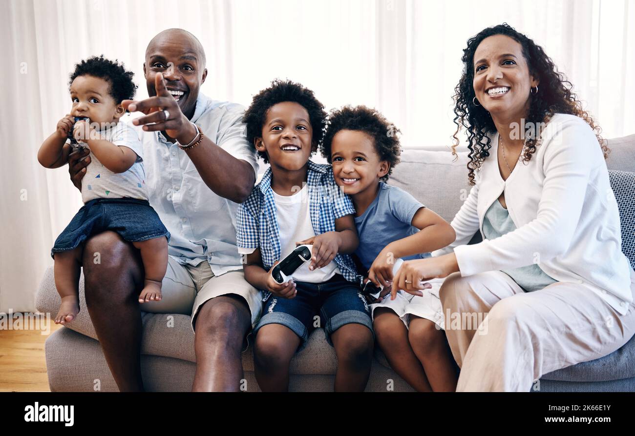 Sibling brothers playing video games together while sitting with their ...