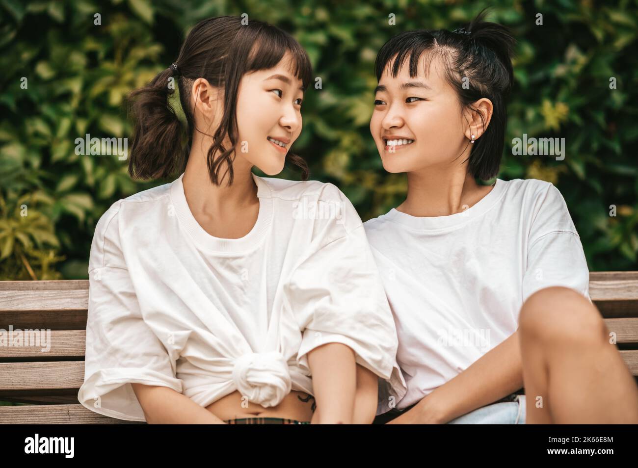 Two cute young girls resting on the bench anad feeling relaxed Stock ...
