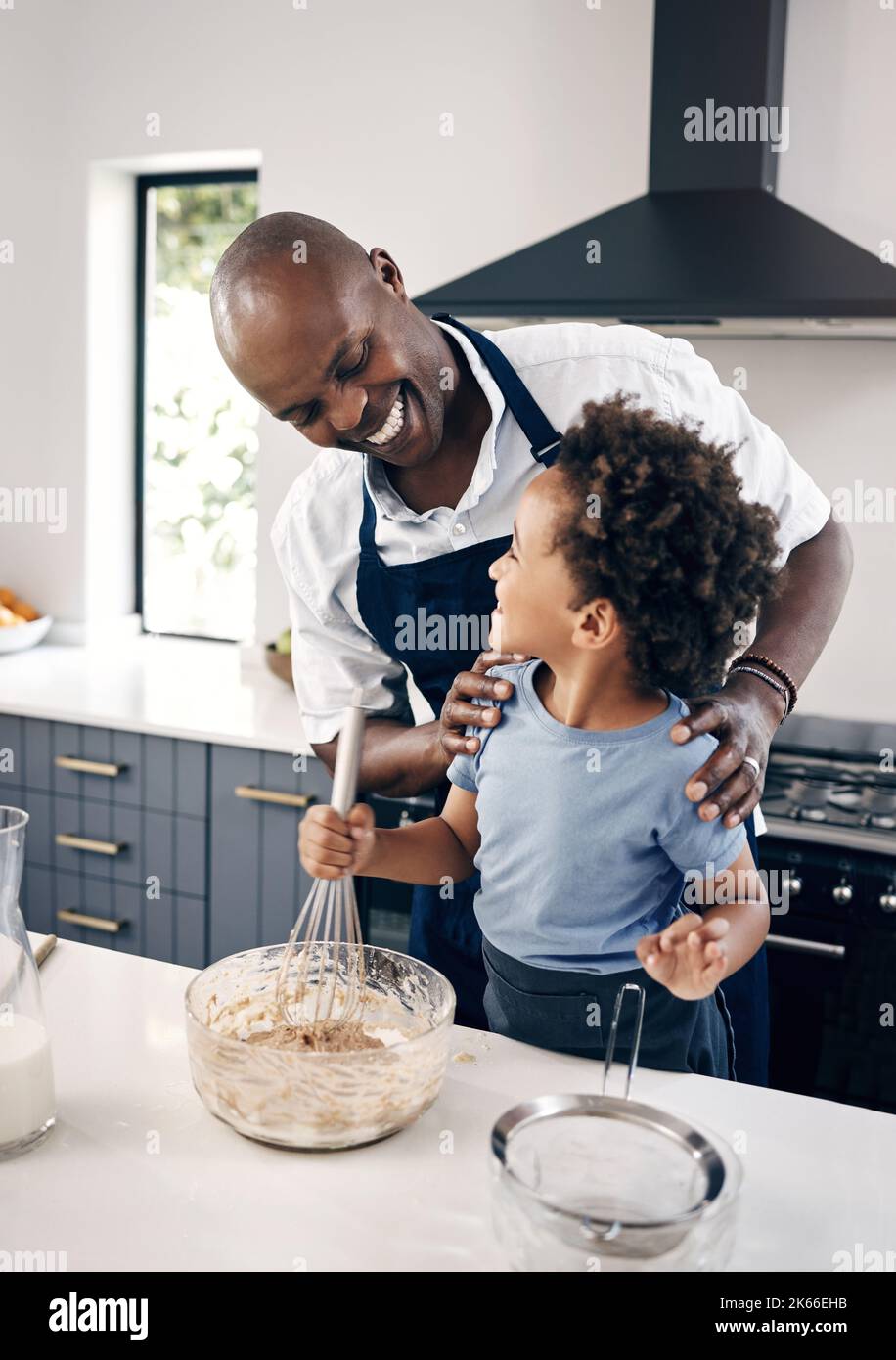 Adorable African American little boy with afro baking in the kitchen at ...