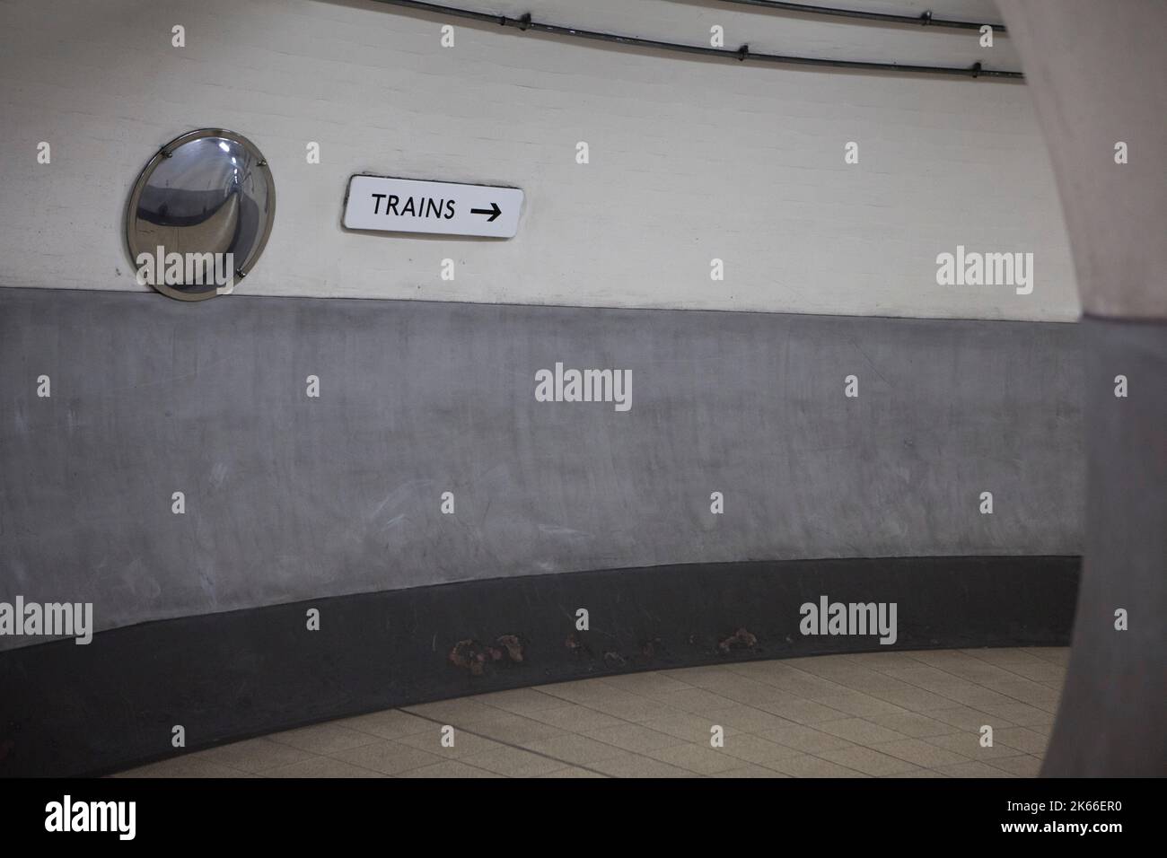 A sign saying 'TRAINS' with an arrow pointing to the right down a ...