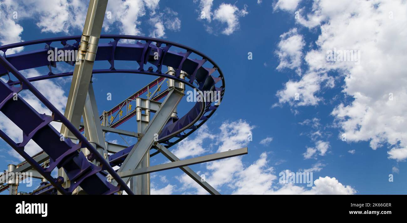 Attraction roller-coaster (switchback) on the background of the cloudy ...