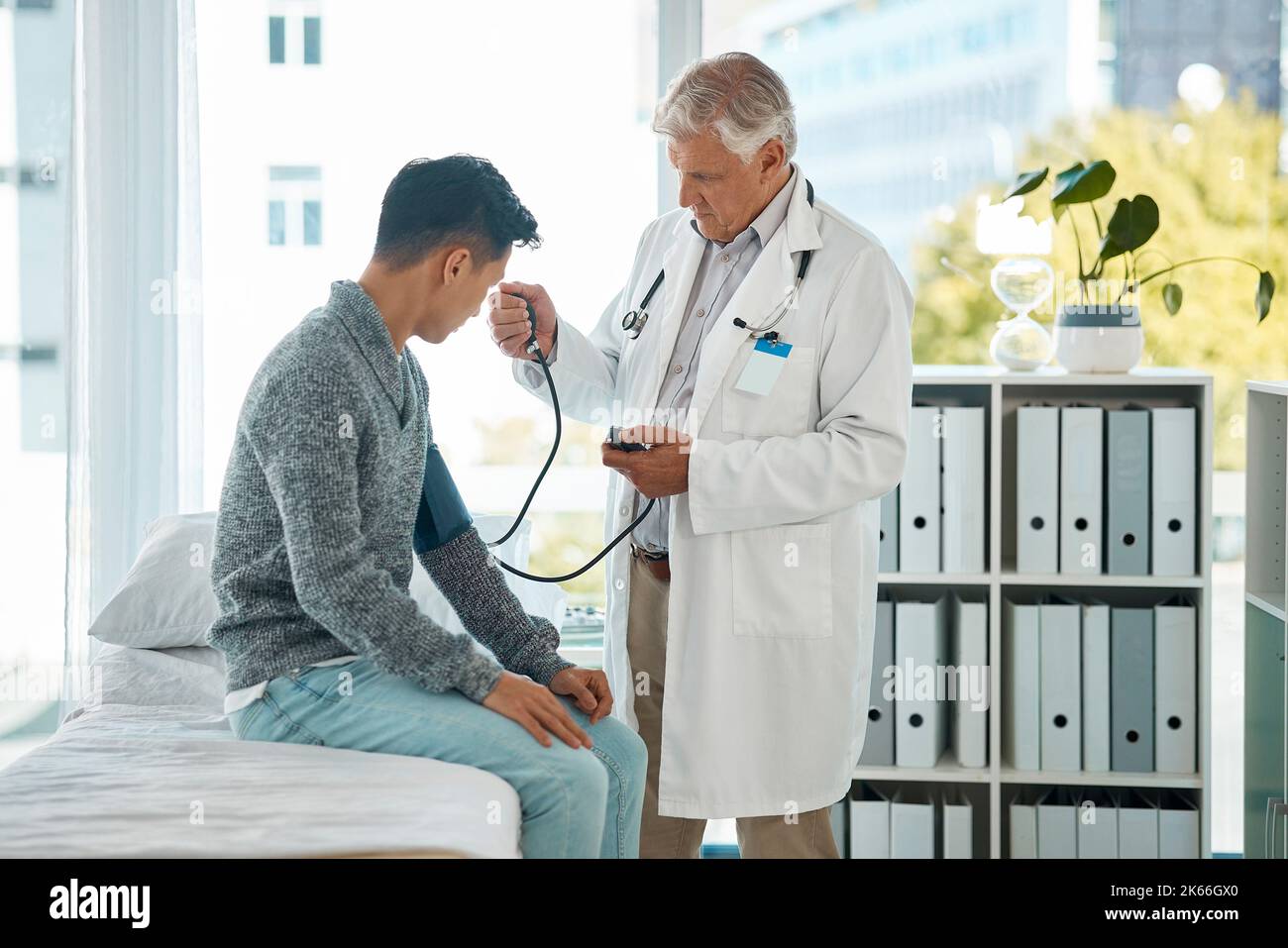 Mature caucasian male doctor doing a checkup checking a young patients ...