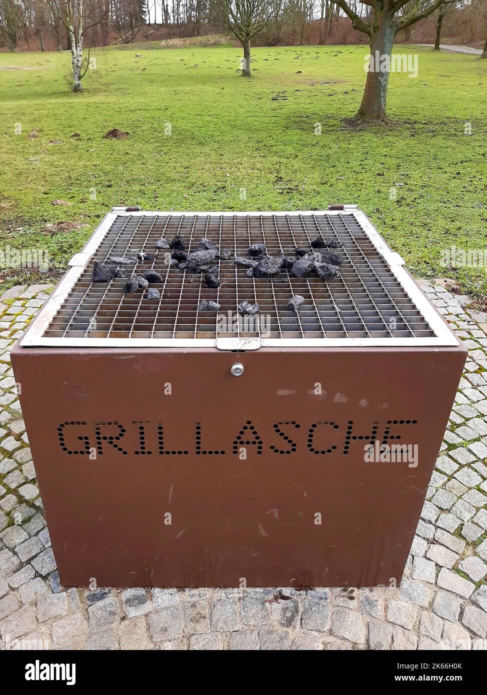 barbecue area with charcoal remains on the grill in a public park ...