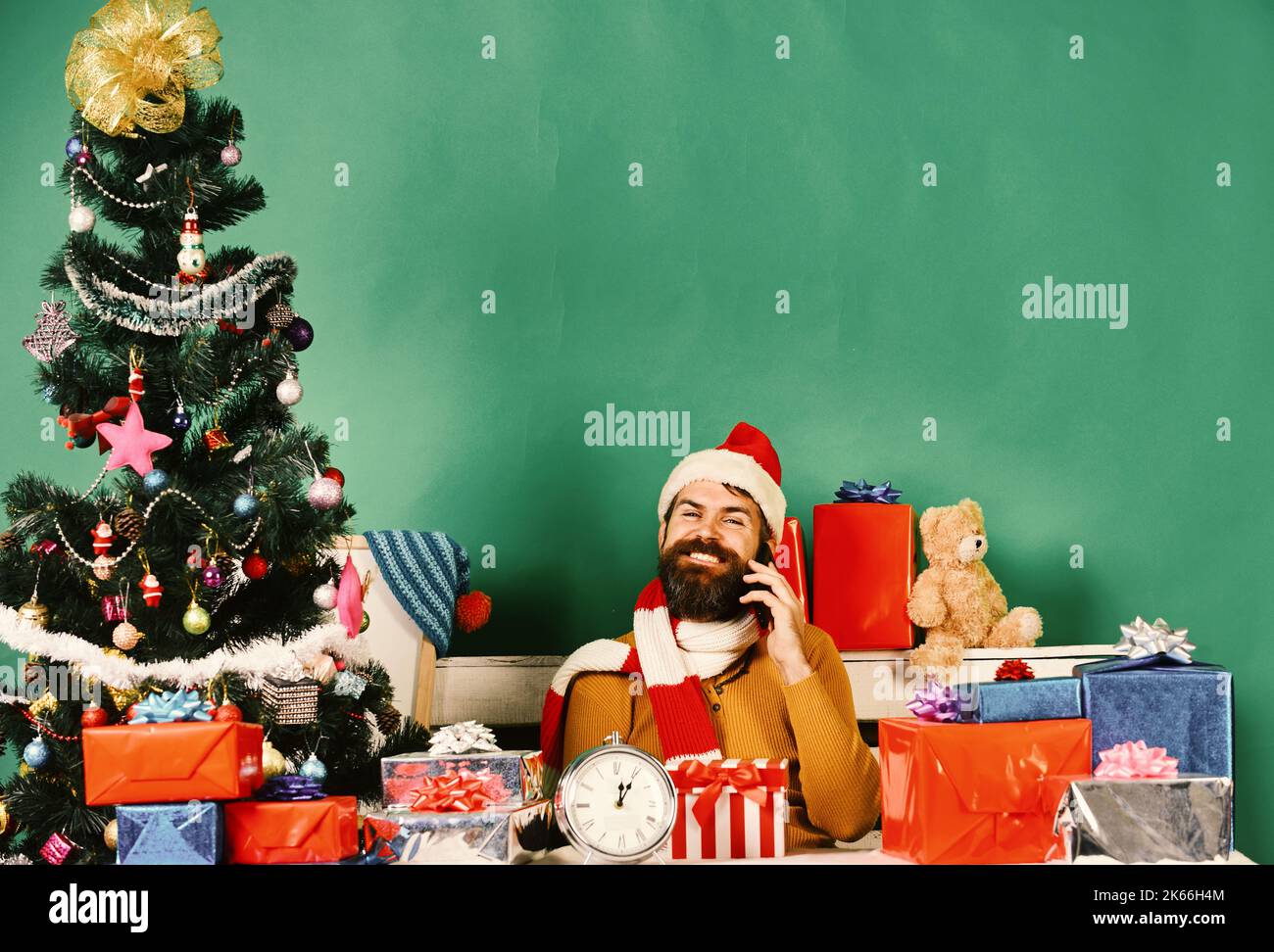 Santa Claus talks on mobile phone on green background Stock Photo - Alamy