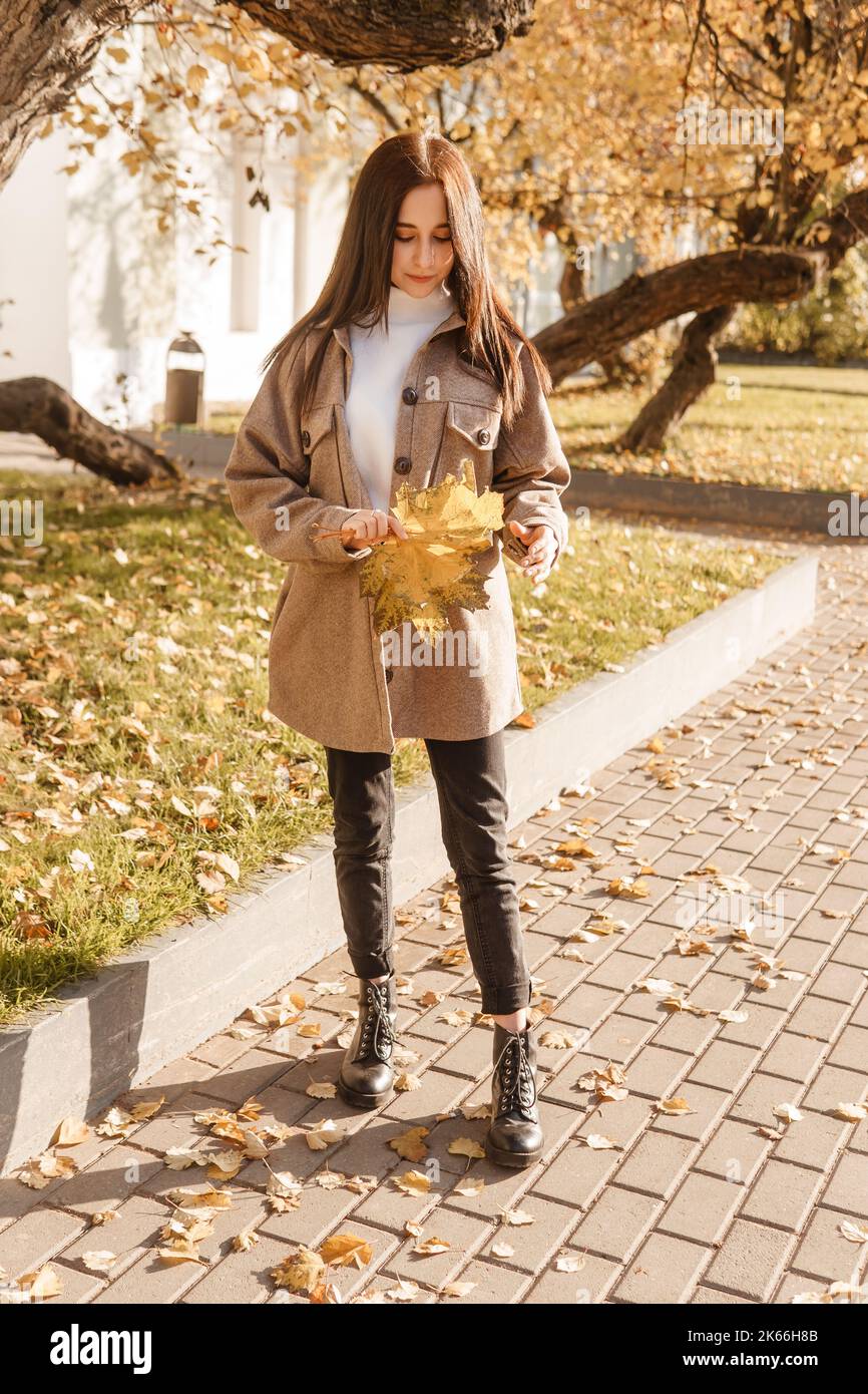 A stylish brunette woman walks around the autumn city. The season is ...