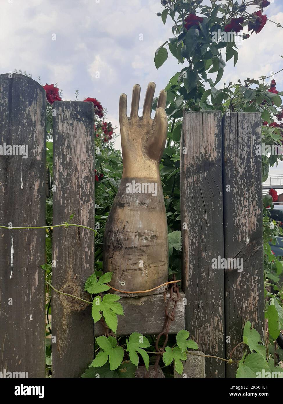 Art work inserted in a garden fence, brass hand, Germany Stock Photo ...
