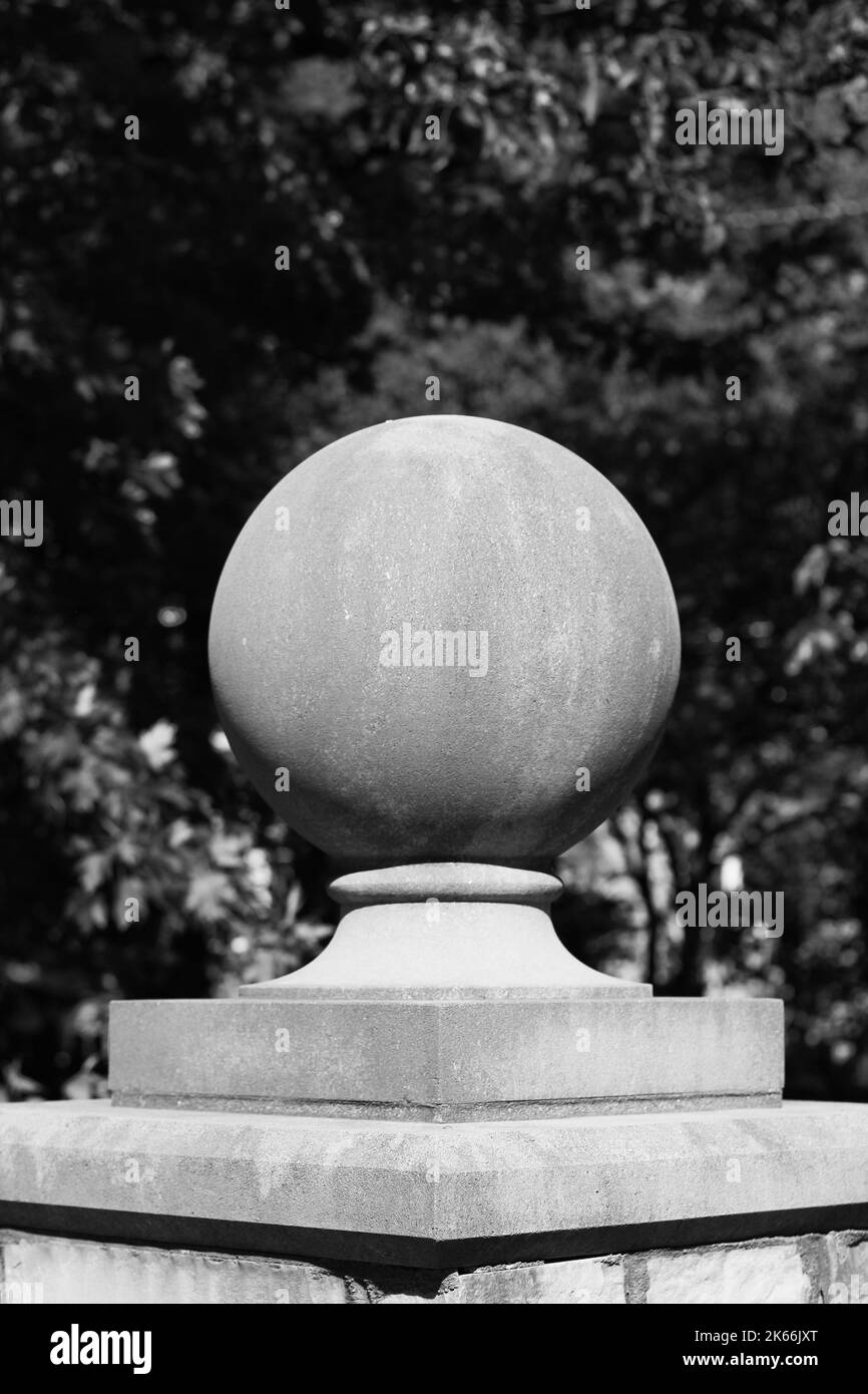 Circular ball on top of a concrete column as a garden decoration in a ...
