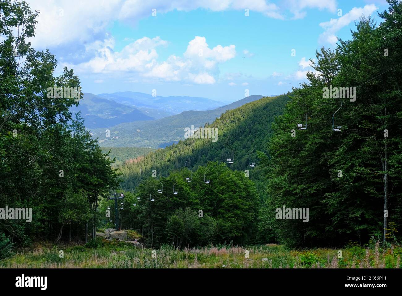 Chairlift across the mountains and cloudy sky. National park Appennino ...