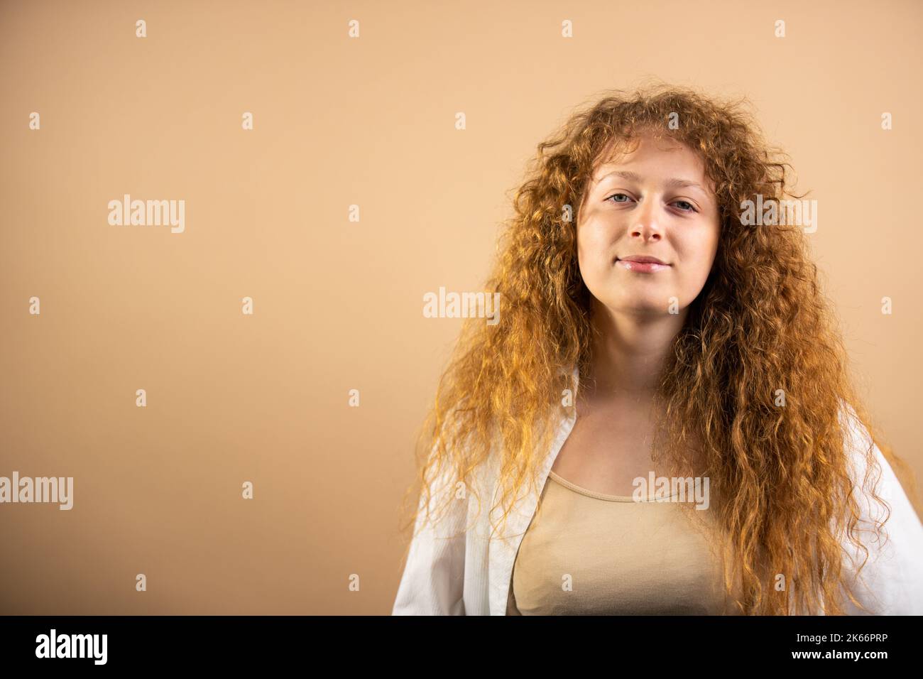 Confident beautiful woman with red long curly hair with attractive look ...