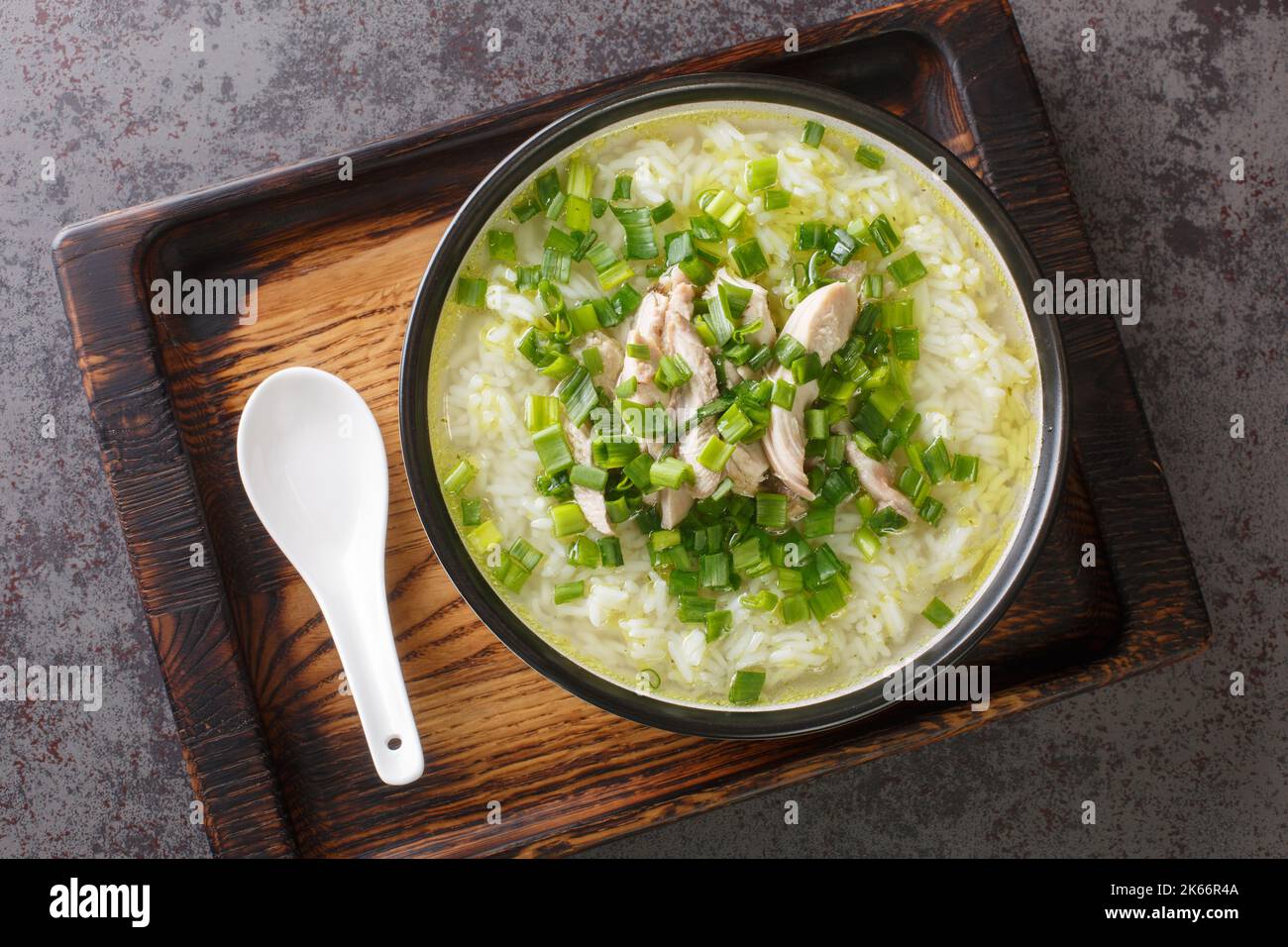 Dak Gomtang Korean Chicken Soup served with rice and green onion close-up in a bowl on the table ...