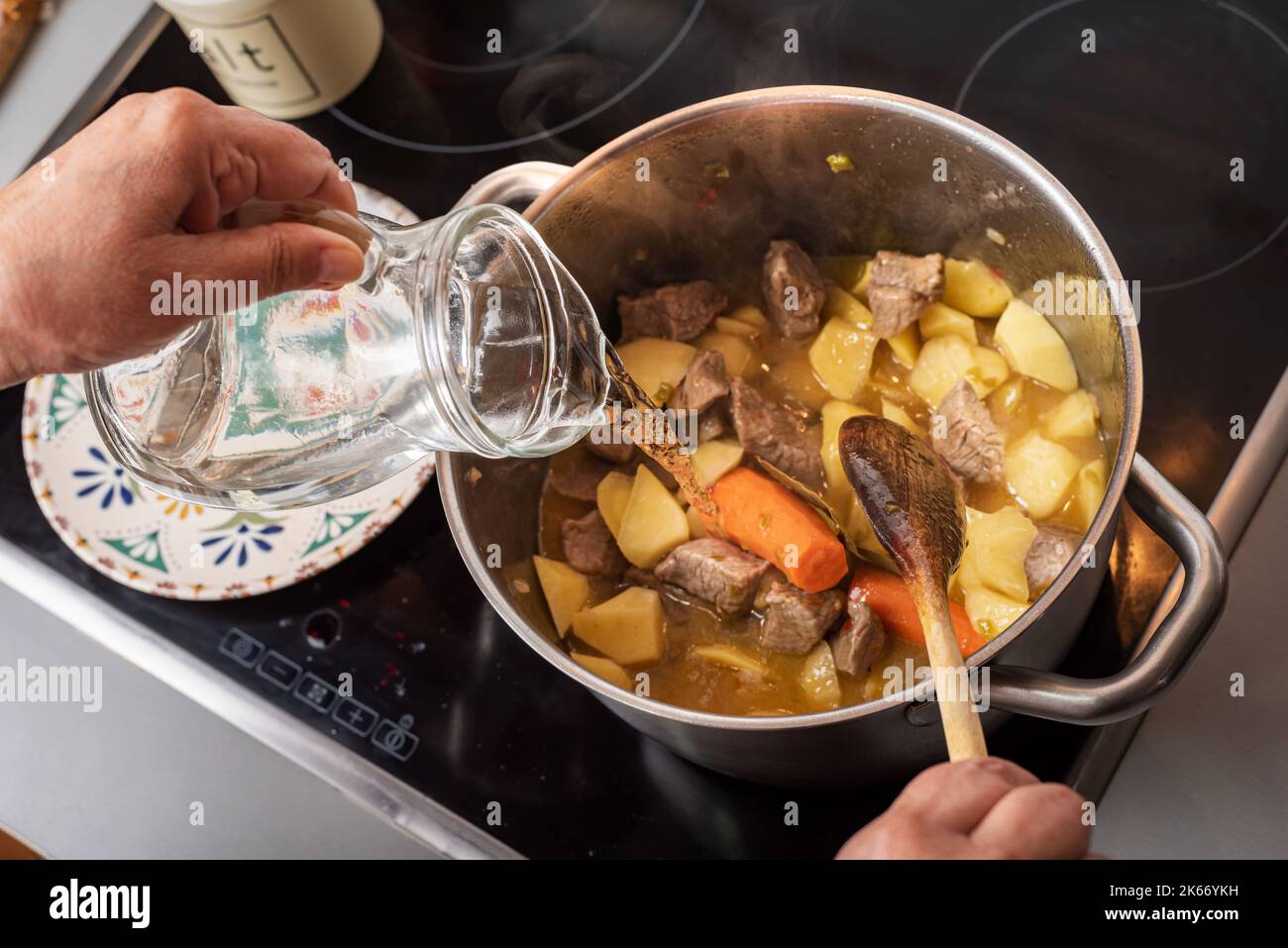Womans hand adding carrot in hi-res stock photography and images - Alamy
