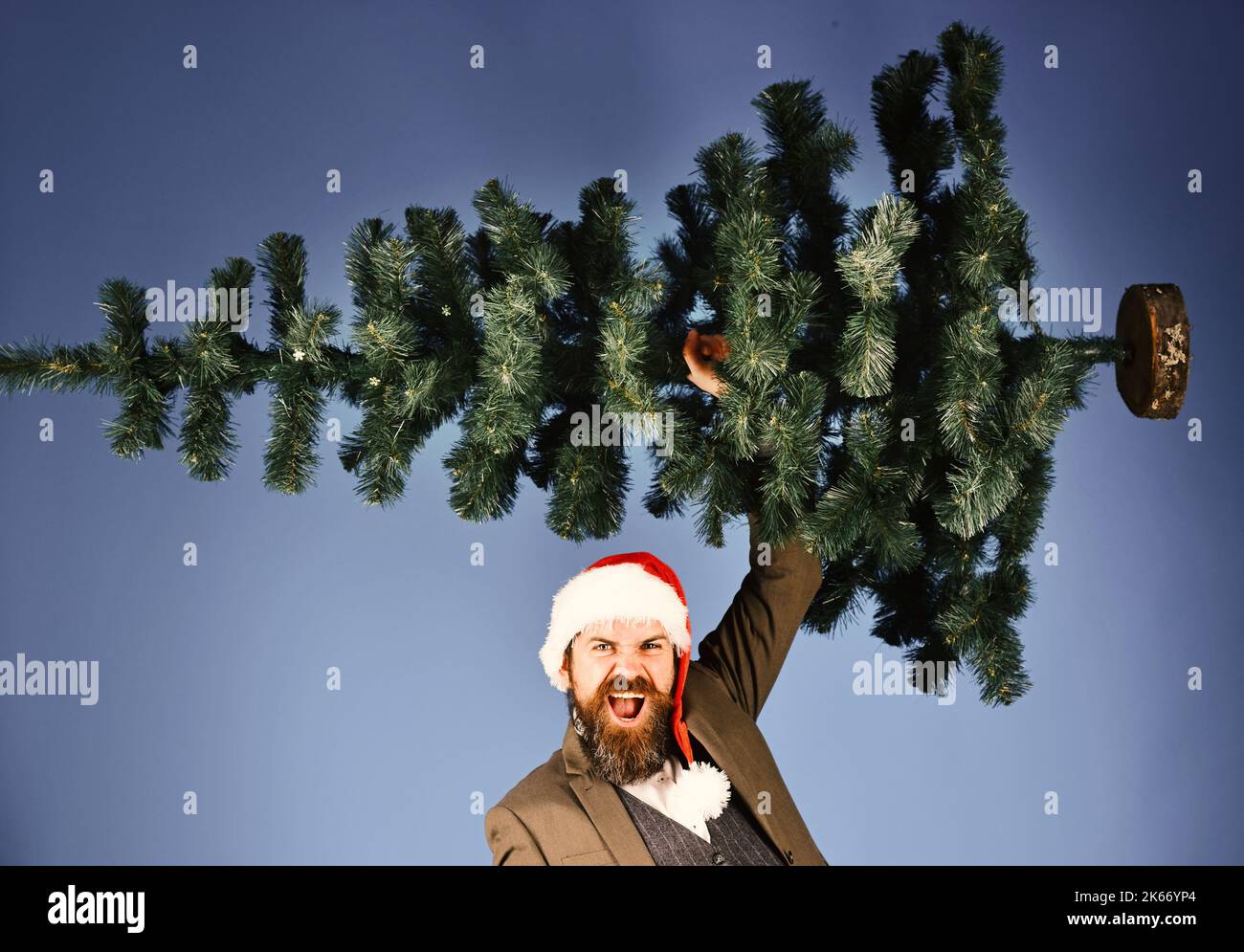 Man in smart suit and Santa hat on blue background Stock Photo - Alamy