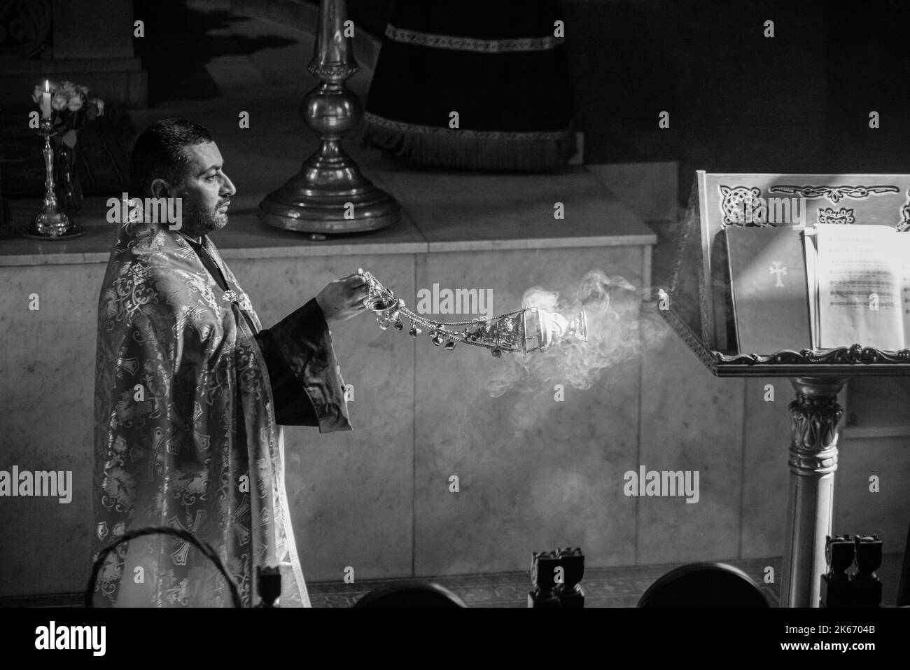 A grayscale of the priest smoking incense during the liturgy, Yerevan ...