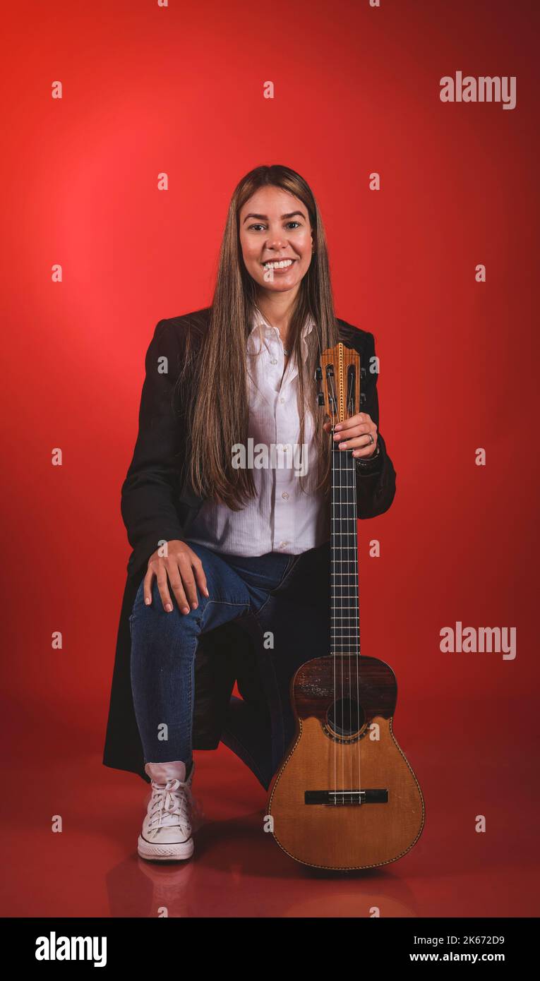 Beautiful young woman playing a CUATRO, typical Venezuelan instrument ...