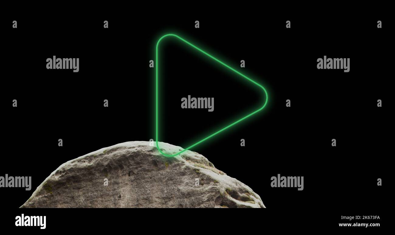 Composite of illuminated digital play button icon over rock against ...