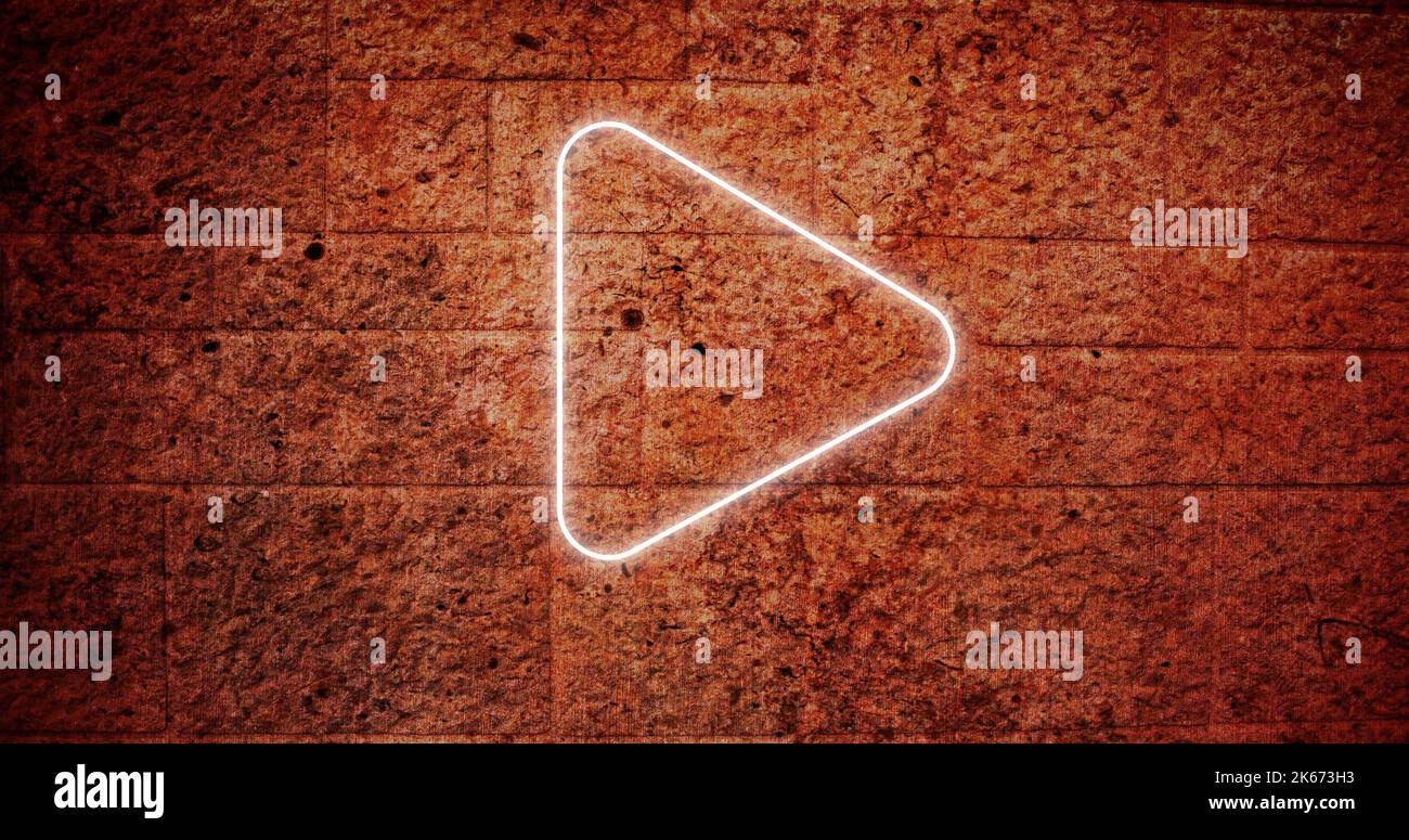 Composite of illuminated white play button icon against grunge wall ...