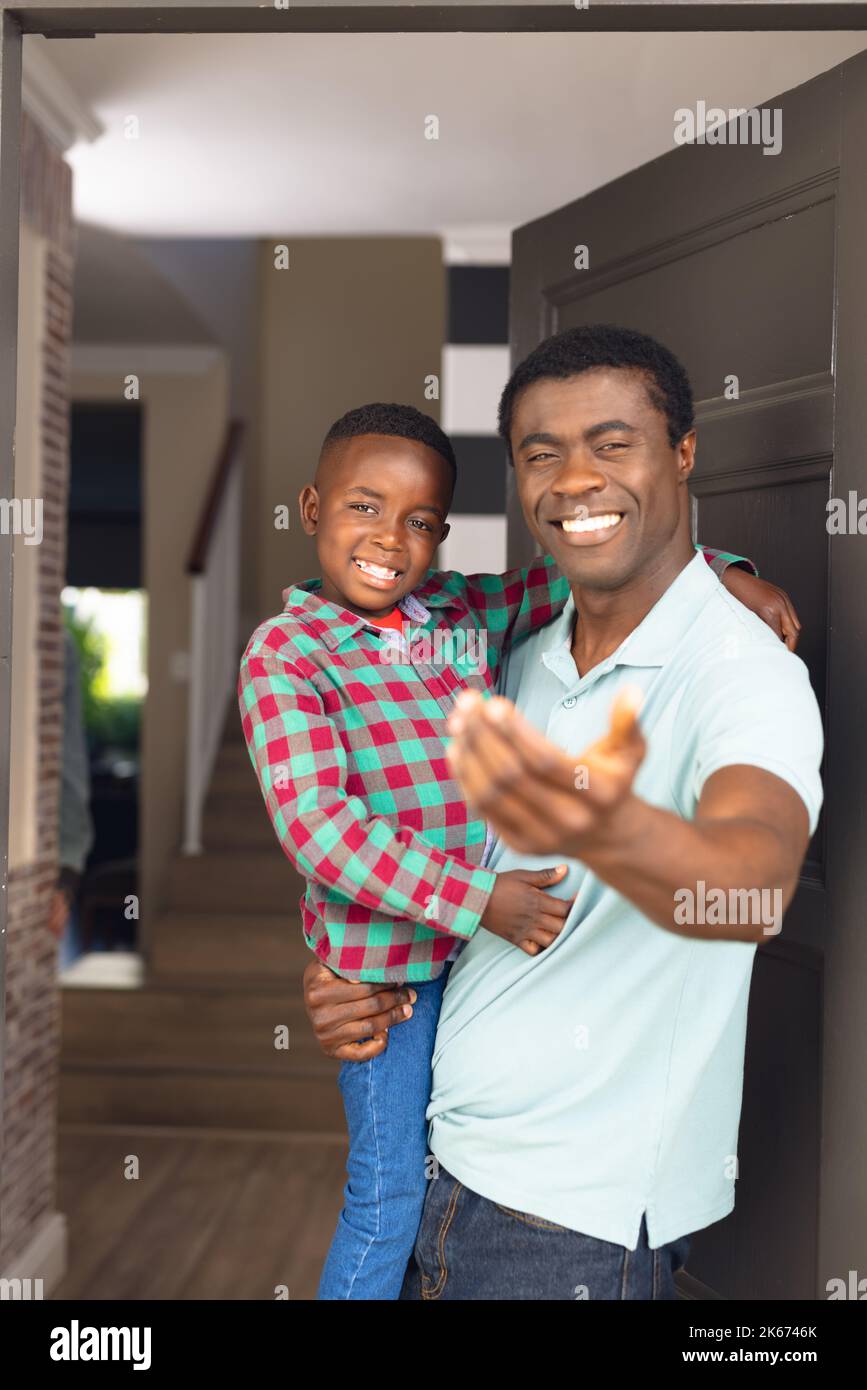 Vertical picture of happy african american son and father welcoming ...