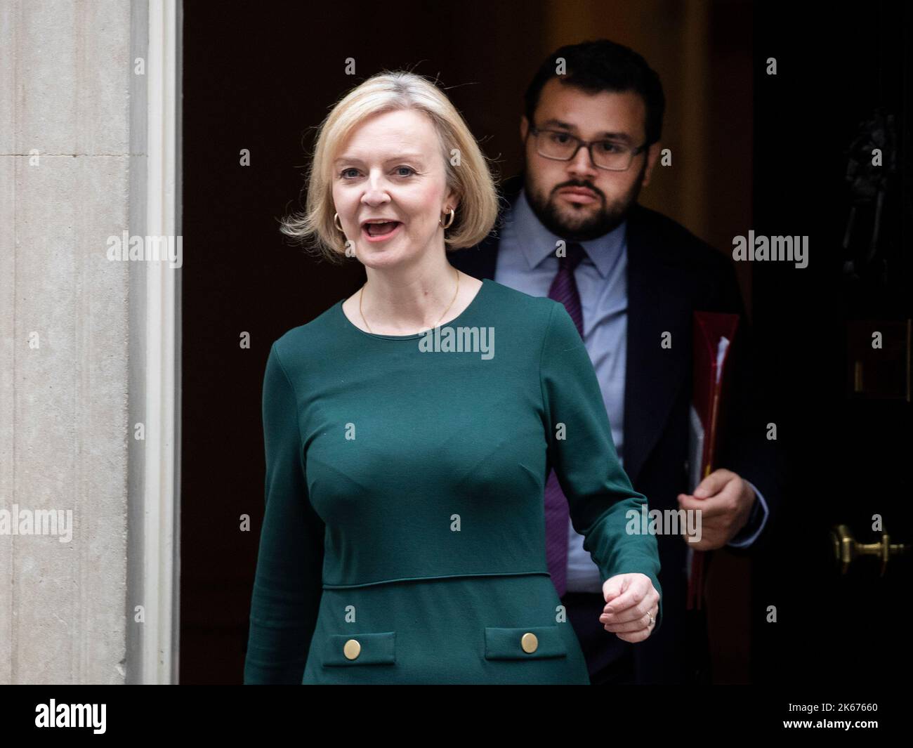 Prime Minister Liz Truss leaves Number 10 Downing Street flanked by her ...