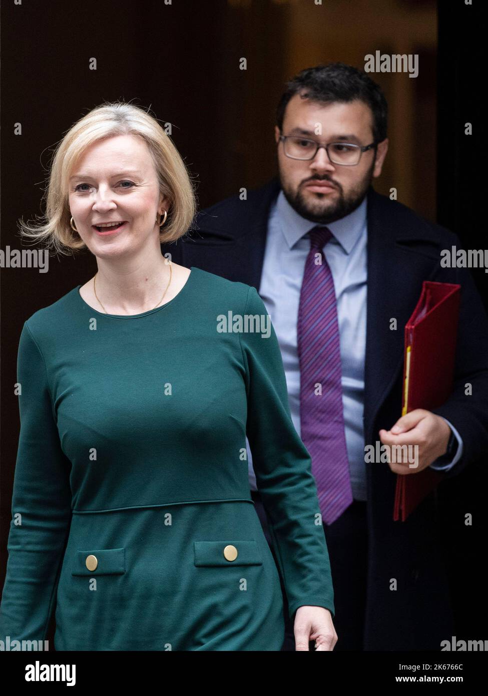 Prime Minister Liz Truss leaves Number 10 Downing Street flanked by her ...