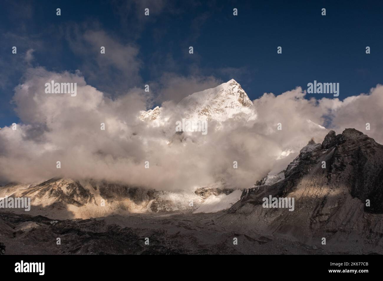 The summit of Himalayan snow caped mountains with dramatic clouds, on ...
