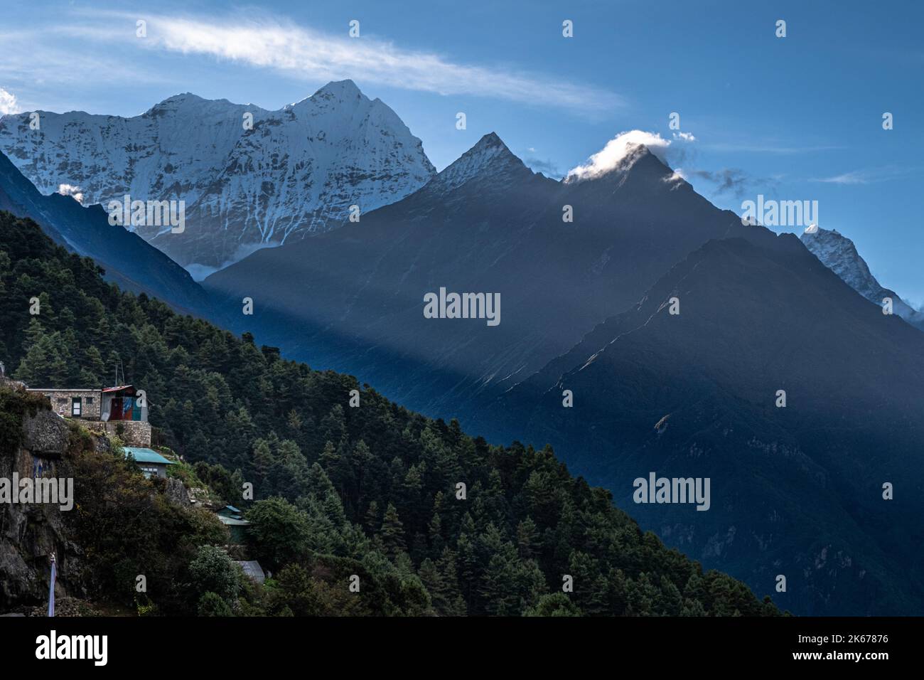 Sun streeking through the Himalayas mountains onto the forest below ...