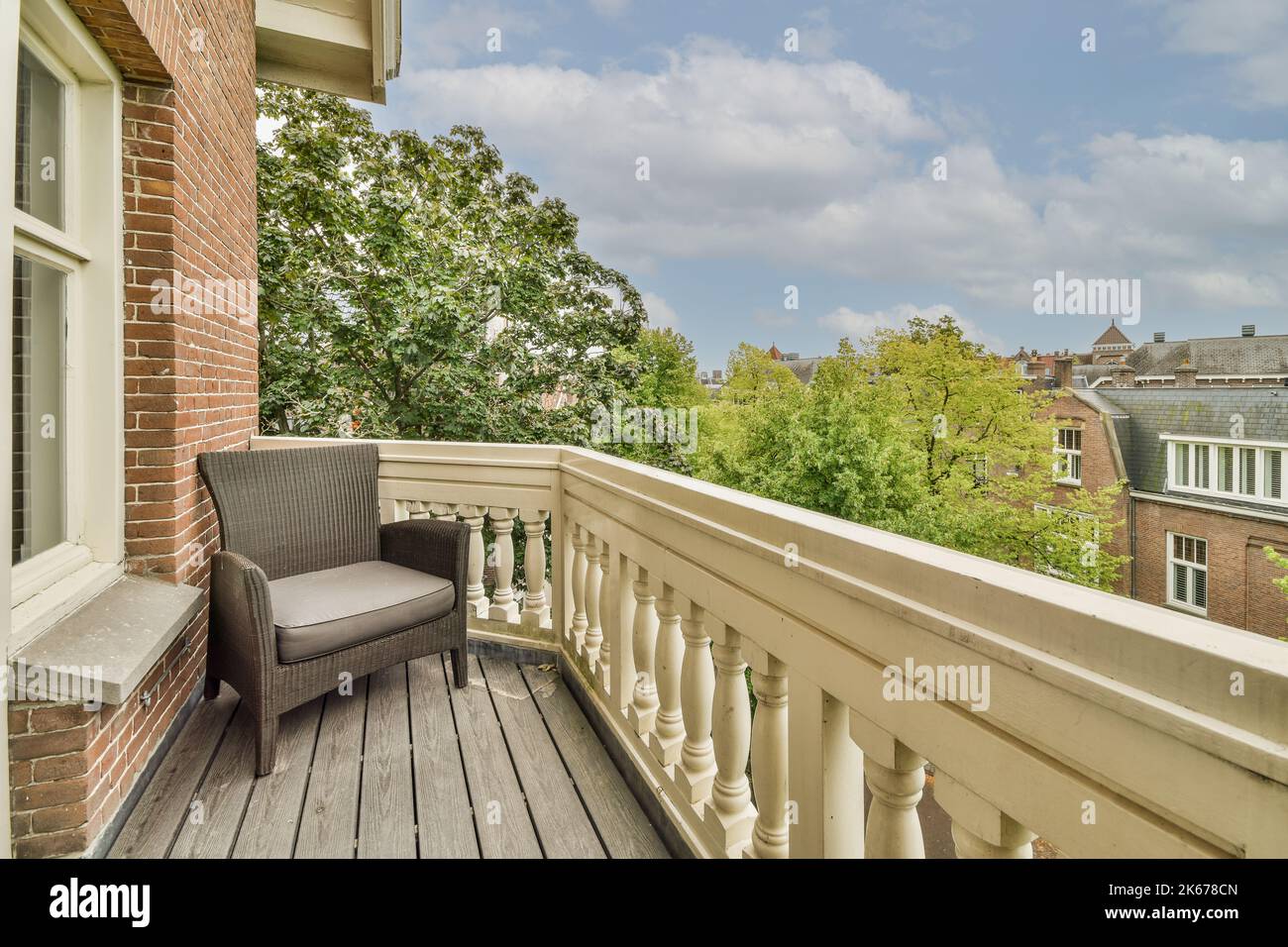 Panoramic view of old brick buildings with trees from small balcony ...