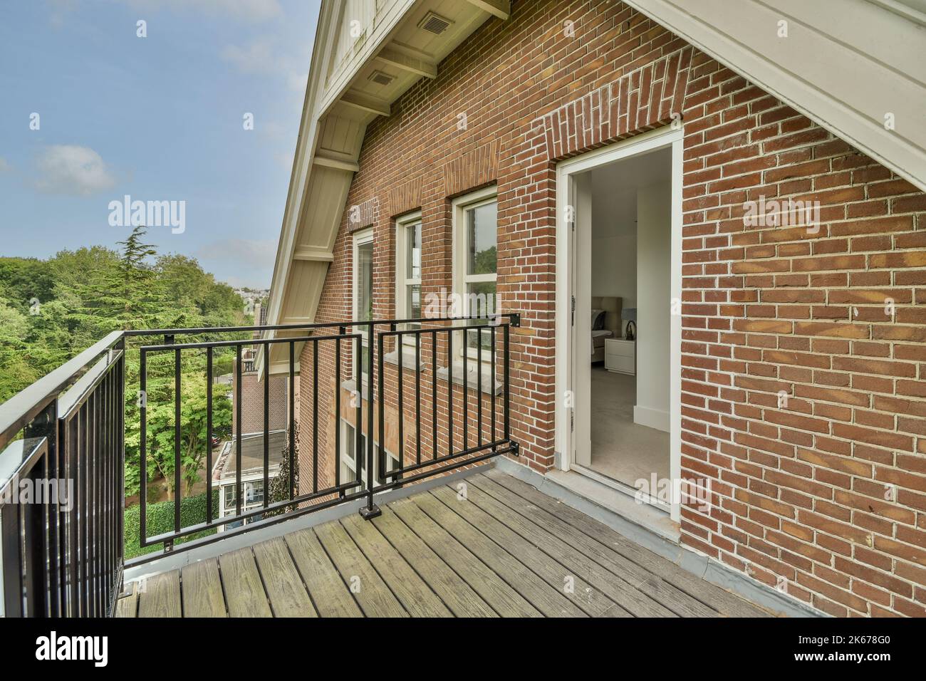 Panoramic view of old brick buildings with trees from small balcony ...