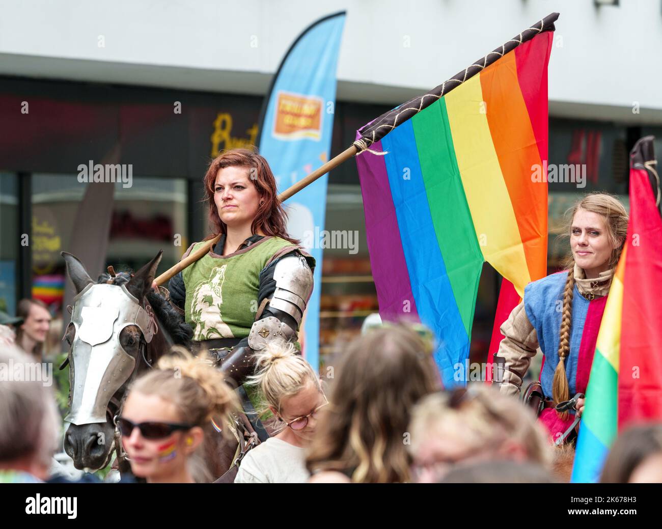 Two women riding on horses with pride flags during the pride parade in ...