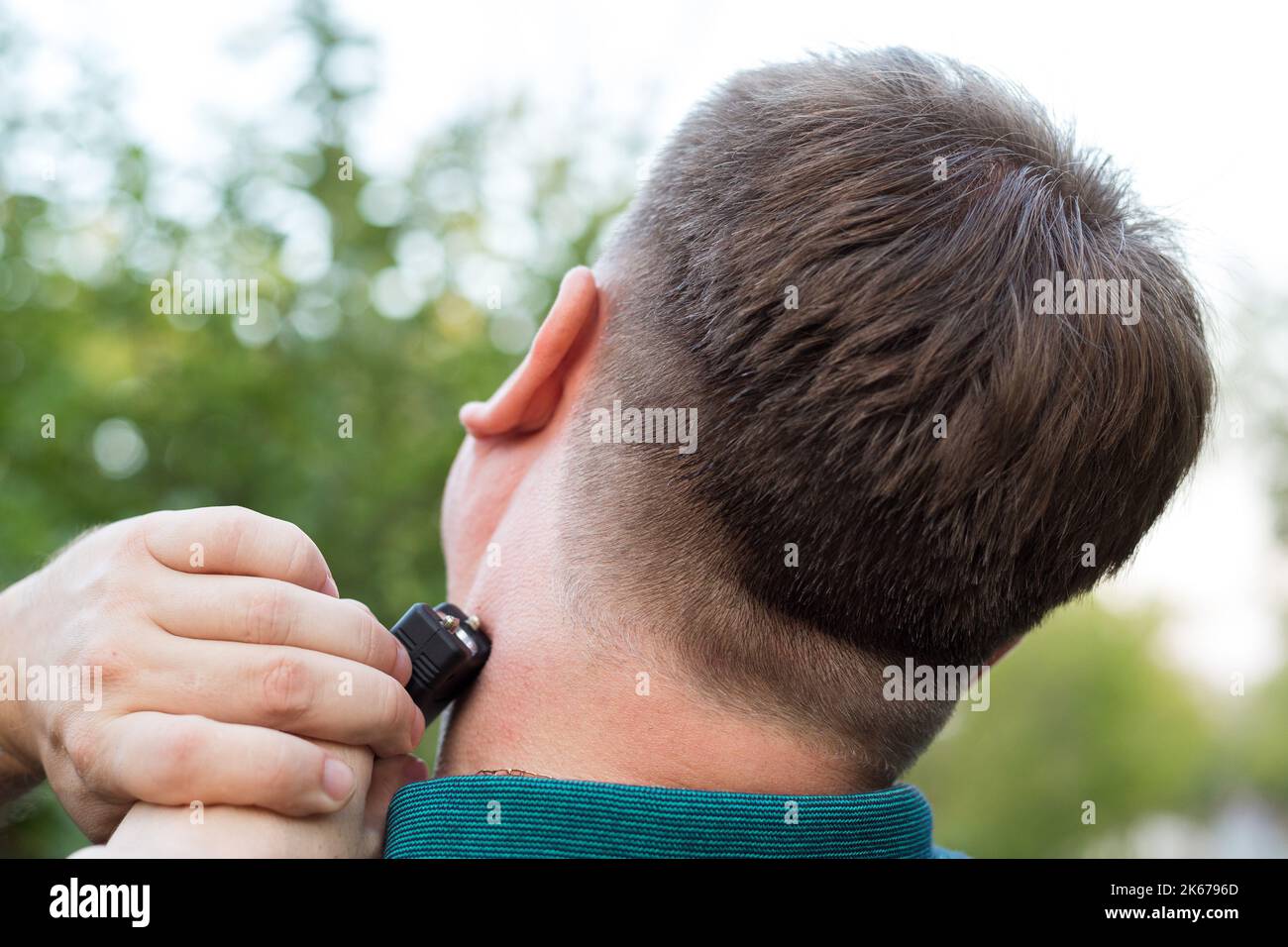 The criminal hits the man in the neck with a stun gun Stock Photo - Alamy