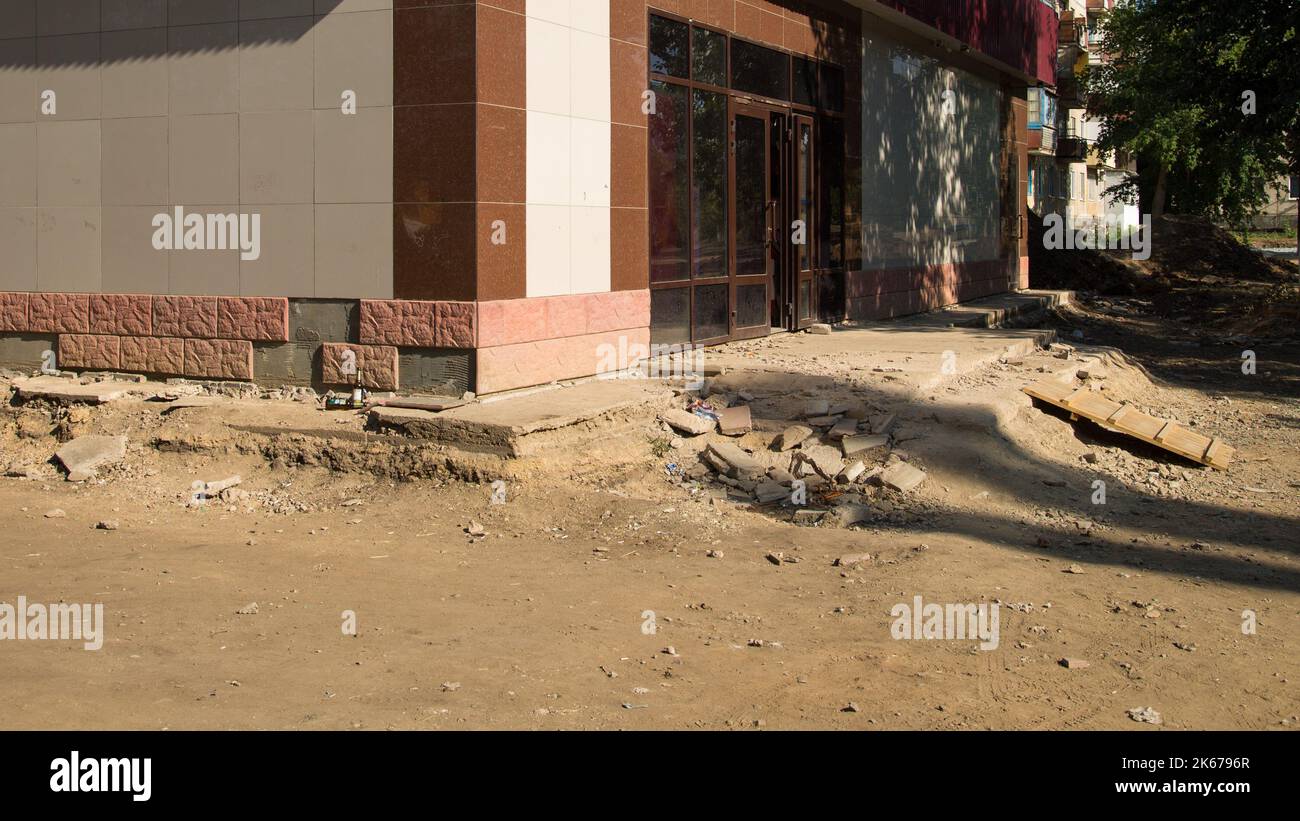 Destroyed entrance to the building, fragments of stairs and debris ...
