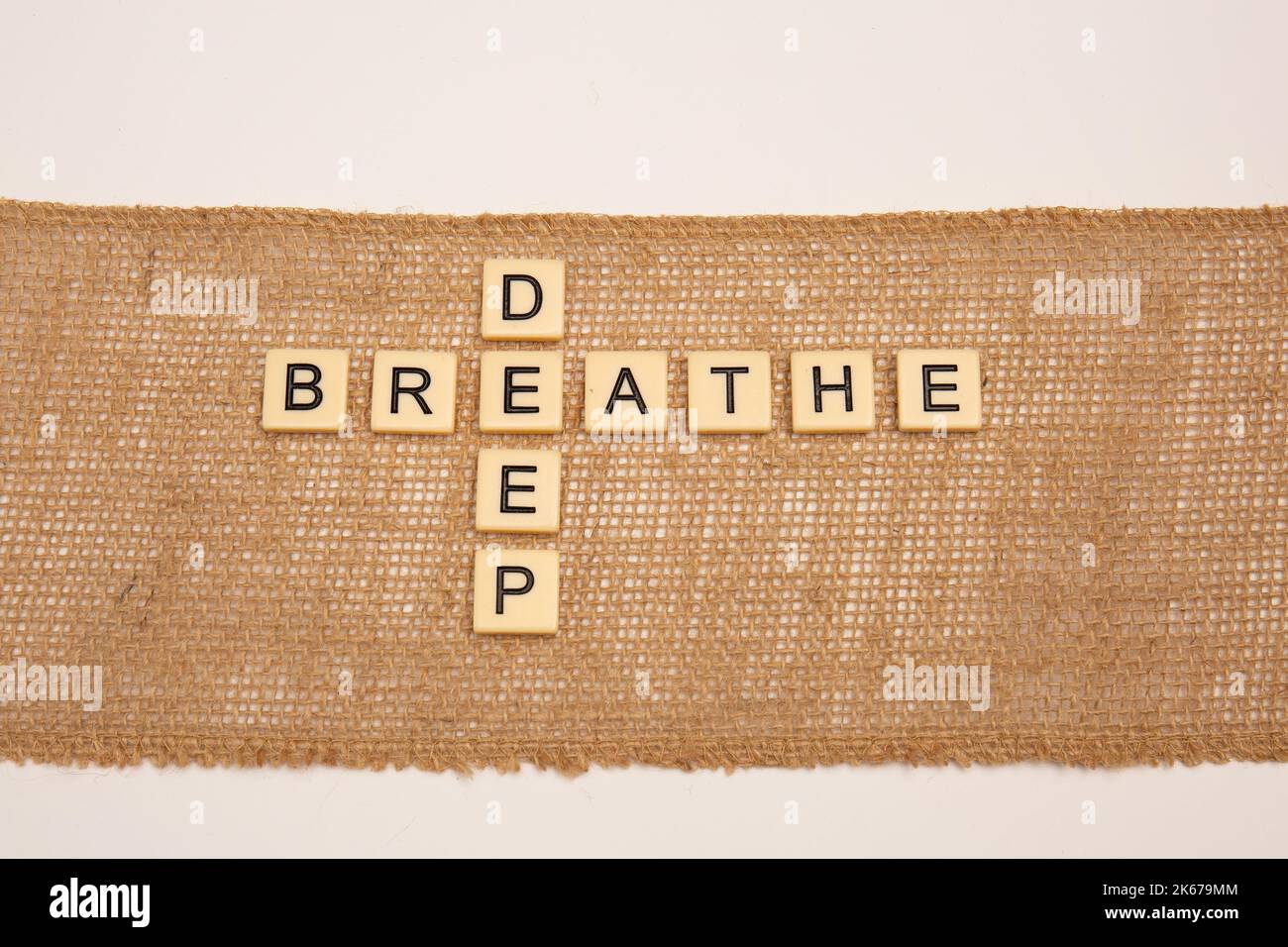 Letter tiles Breath Deep lying on jute natural sackcloth isolated on ...