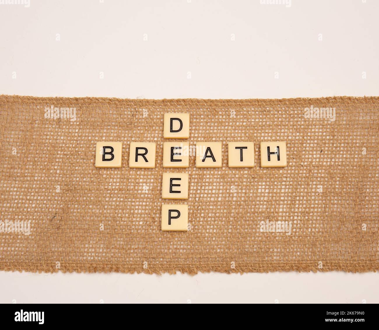 Letter tiles Breath Deep lying on jute natural sackcloth isolated on ...