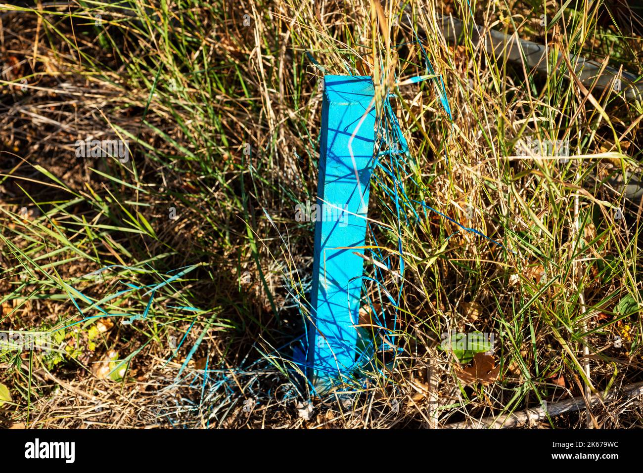 Painted wooden post making underground mains water pipe Stock Photo - Alamy
